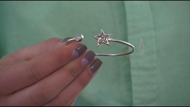 Student helping MDA with bracelets