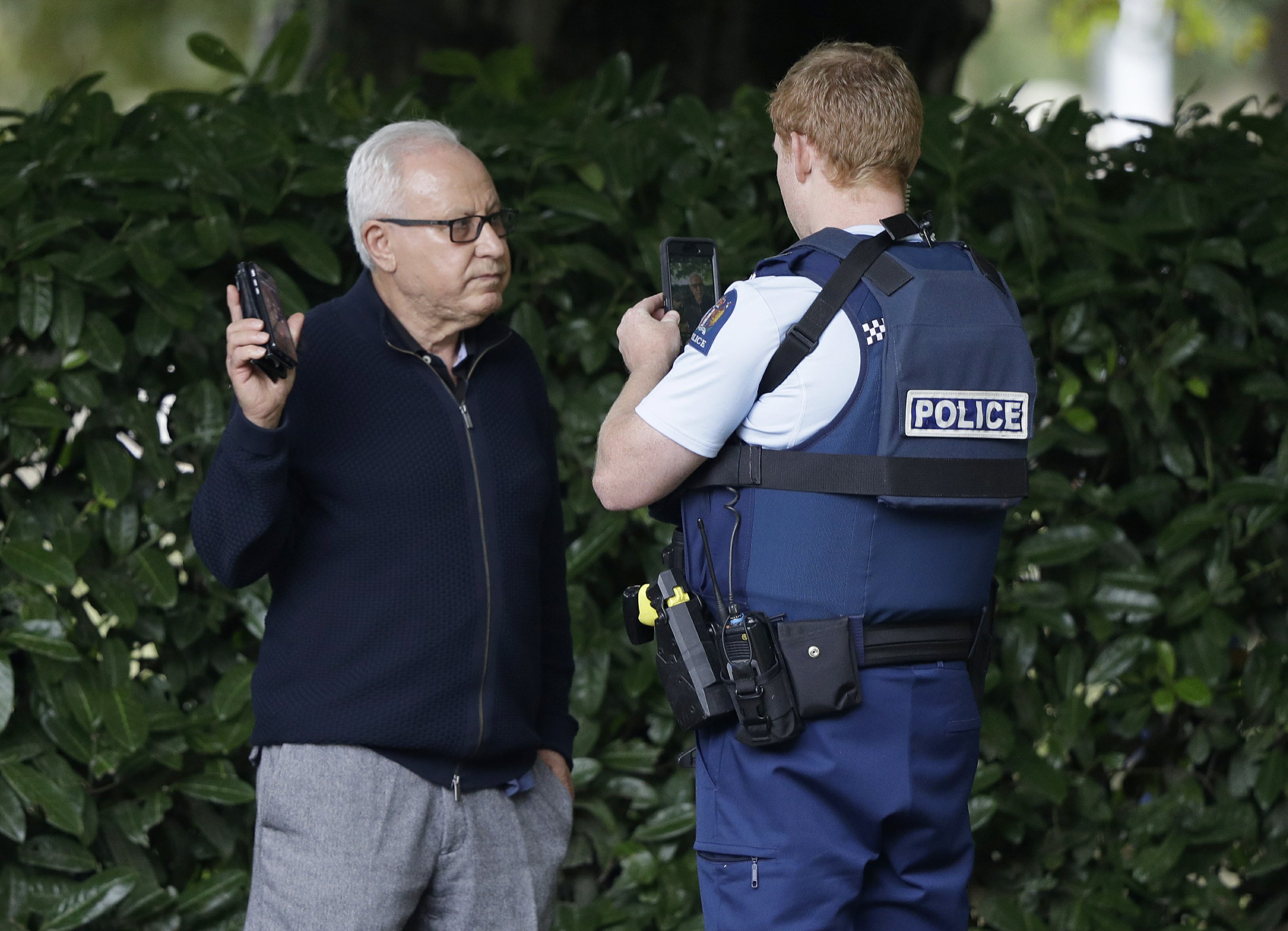 A Police Officer Photographs A Witness Near A Mosque In Central ...